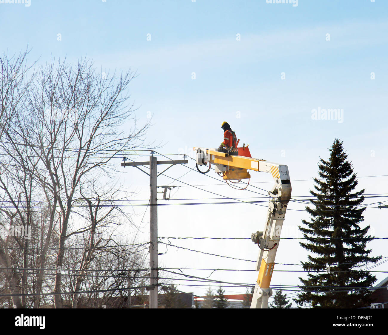 Worker from electrical company making repairs during winter, ice rain ...