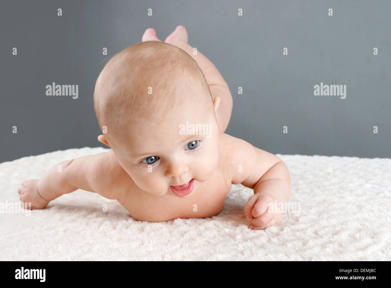 Cute baby trying to roll from belly to back, child development concept ...