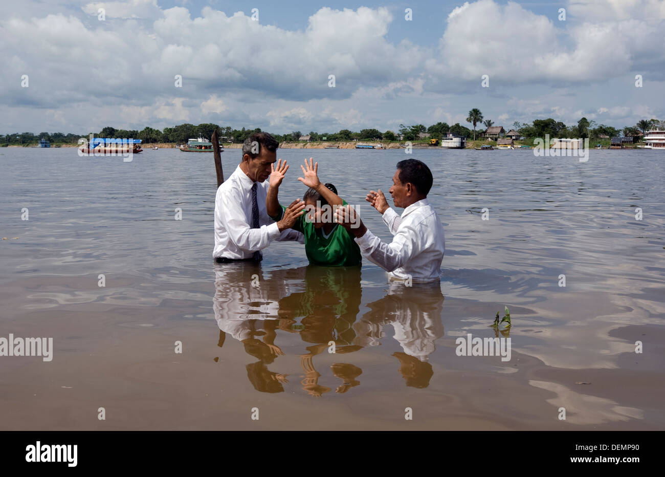 A woman is being baptized by the ritual of religion evangelist in the ...