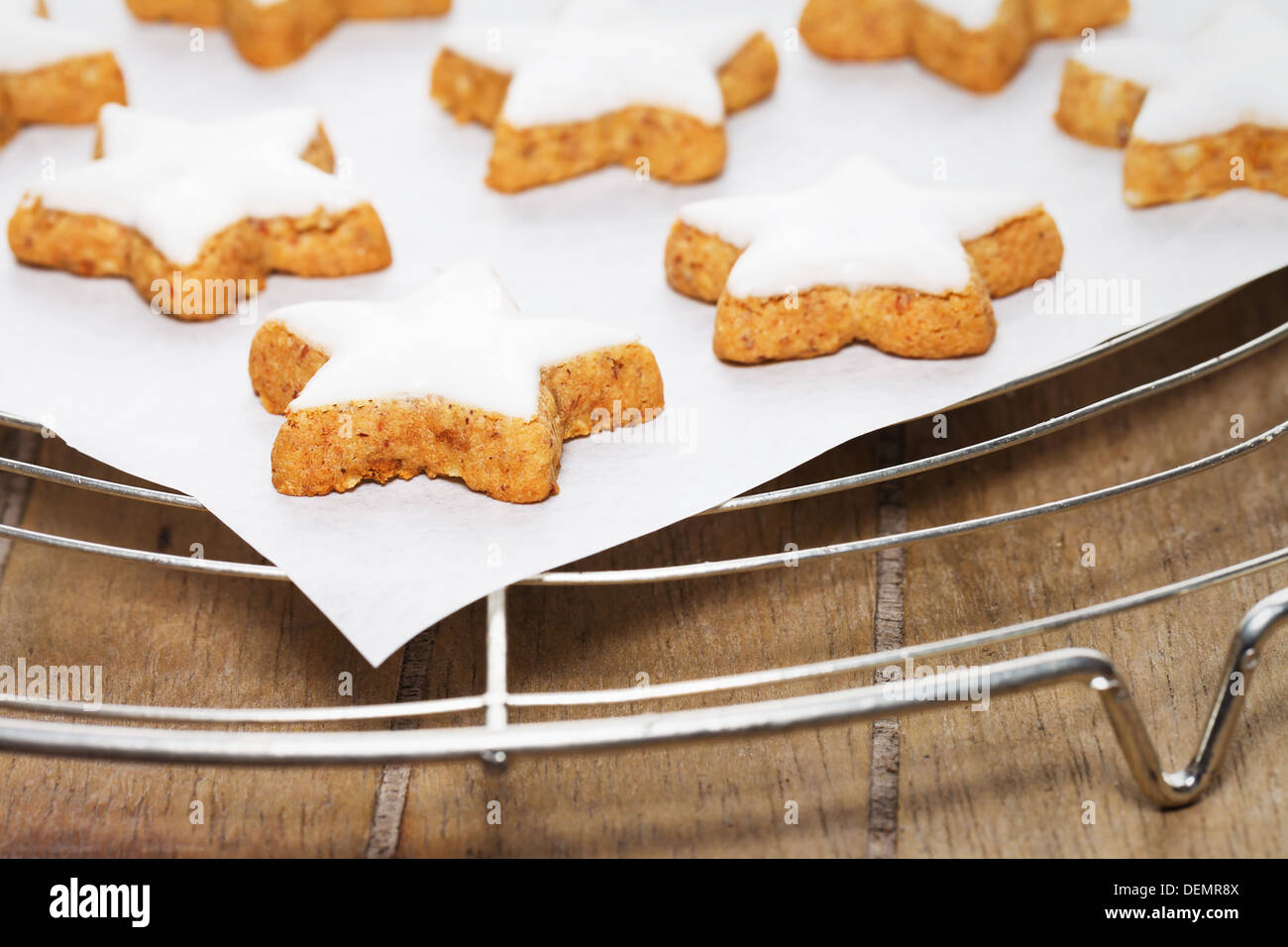 cinnamon stars on a parchment paper on a cooling grid with wooden ...