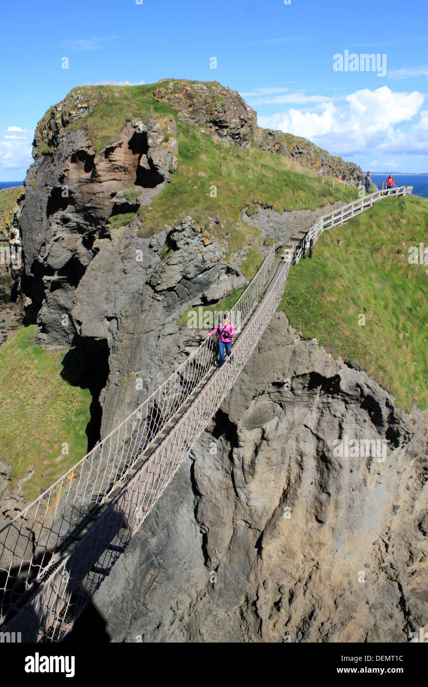 Woman crossing Carrick-a-Rede, rope bridge on the Causeway Coastal ...