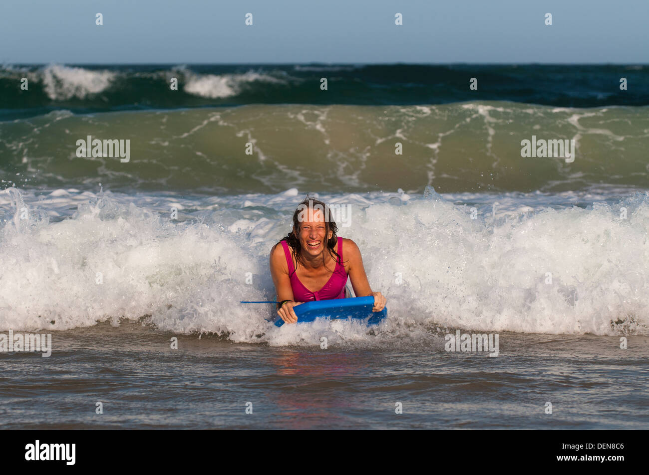 Mature fit healthy woman boogey (or body) boarding in the surf at the ...