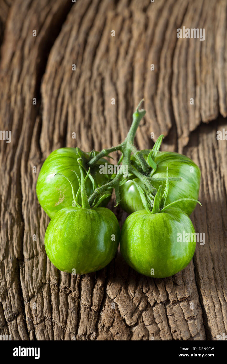 Four ripe Green Zebra Tomatoes on a old rustic wooden Table Stock Photo ...