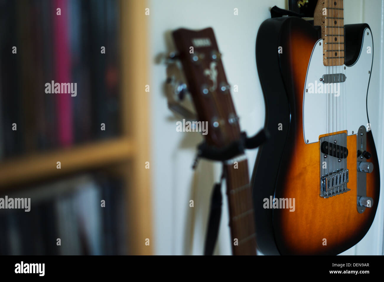 Guitars hanging on a bedroom wall beside a CD rack Stock Photo - Alamy