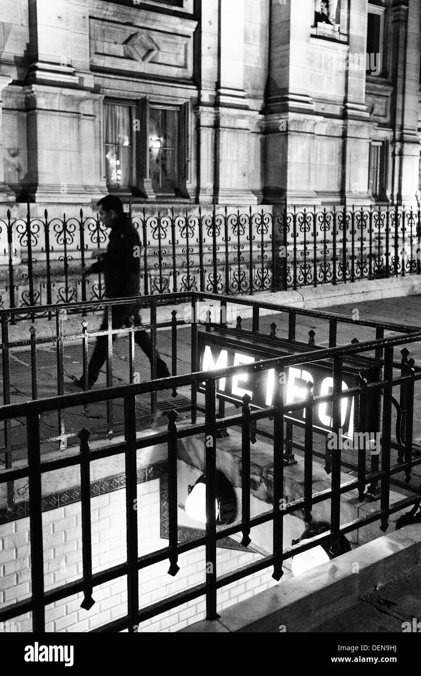 Man walking past the Hôtel de Ville Metro entrance at night, Paris ...