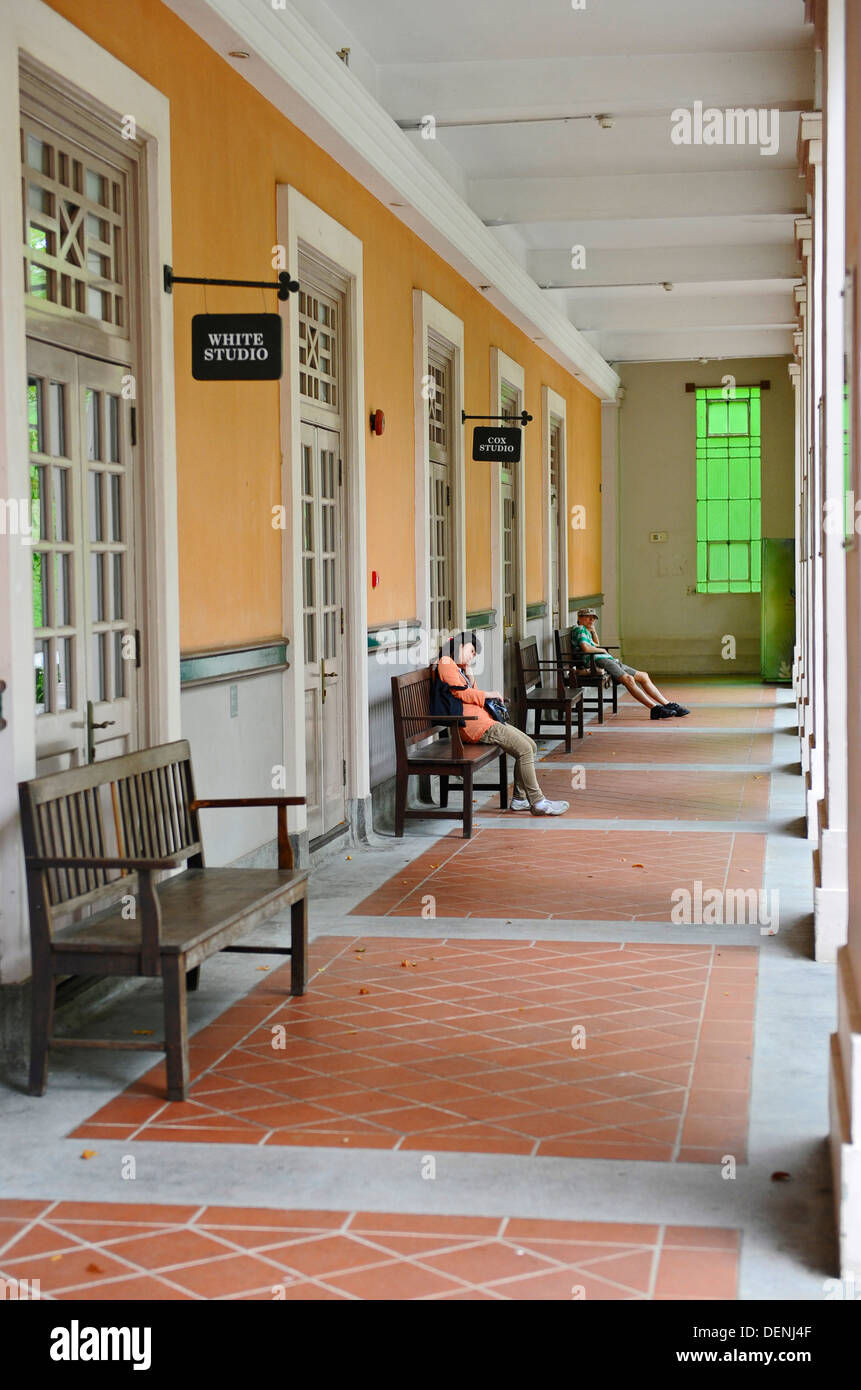 Tired man and woman resting on the rear ground floor corridor seating ...