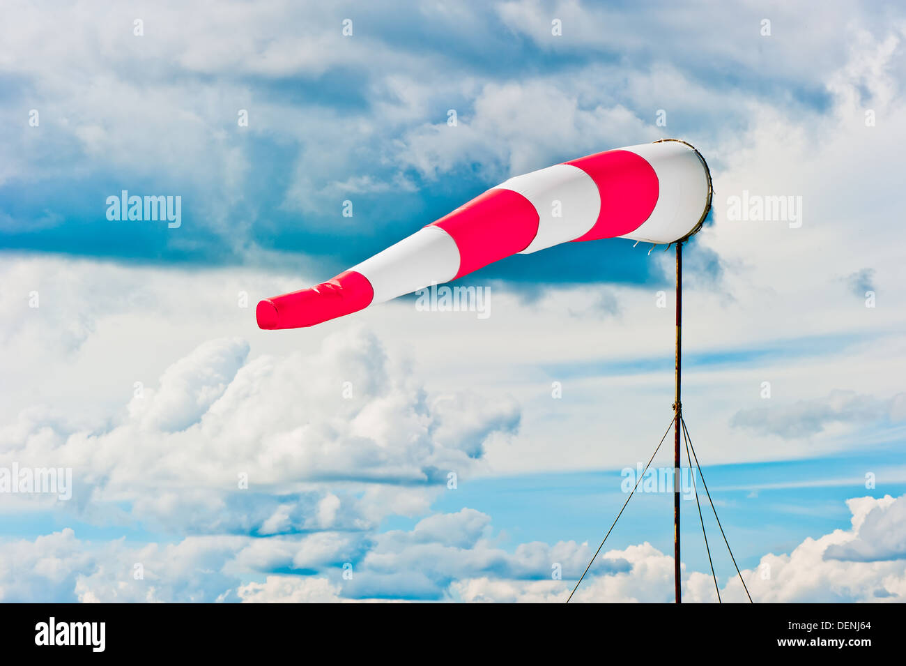 striped windsock at the airport on the background of beautiful clouds ...