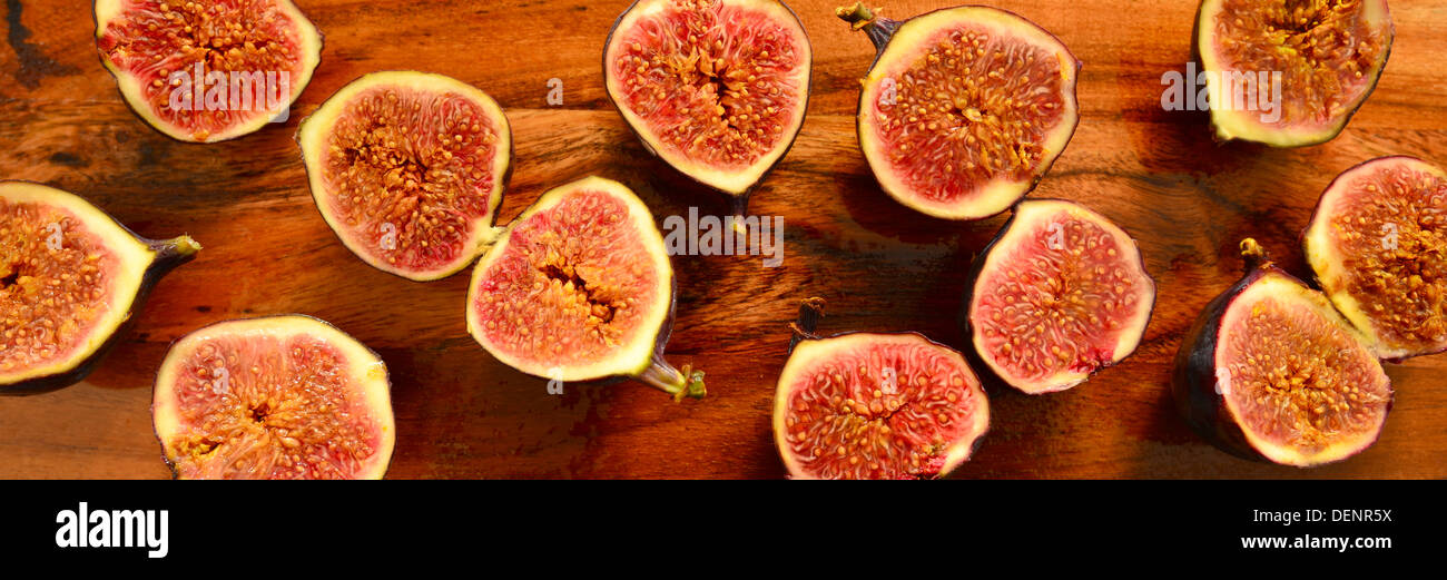 Figs sliced in half on a wooden chopping board Stock Photo - Alamy