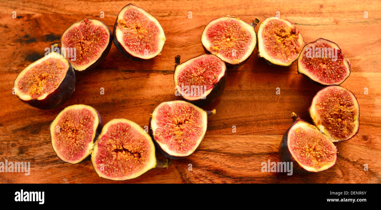 Figs sliced in half on a wooden chopping board Stock Photo - Alamy