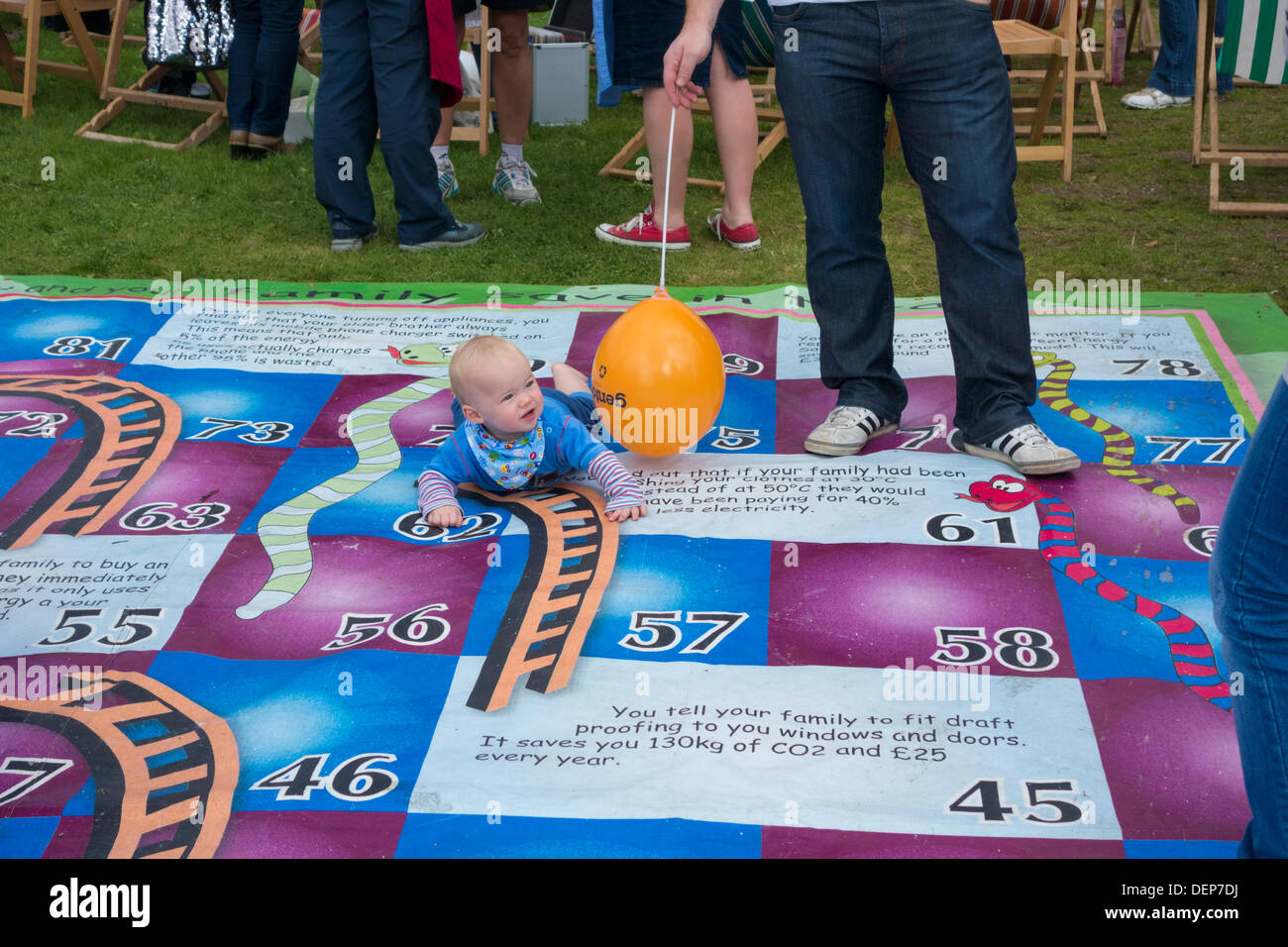 Baby crawling on Snakes and Ladders game which has energy saving tips ...