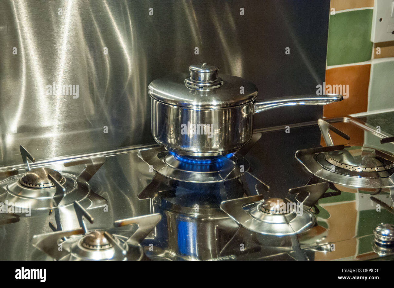 stainless steel pan simmering on oven hob Stock Photo - Alamy