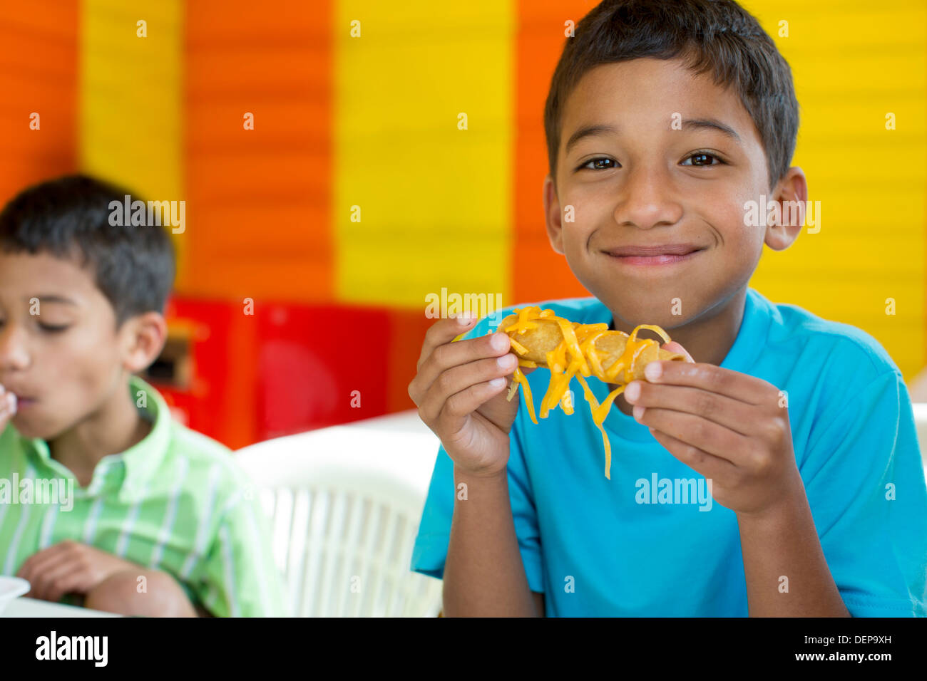 Hispanic boy eating in restaurant Stock Photo - Alamy