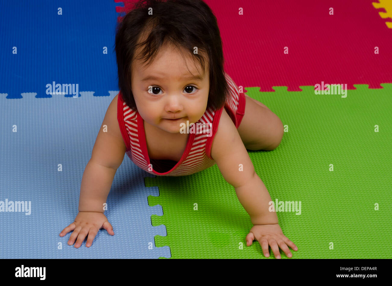 Baby crawling looking at camera Stock Photo - Alamy