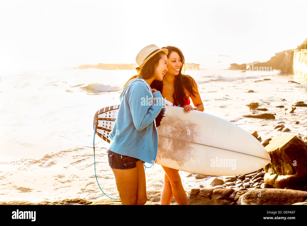 Women carrying surfboard on beach Stock Photo - Alamy