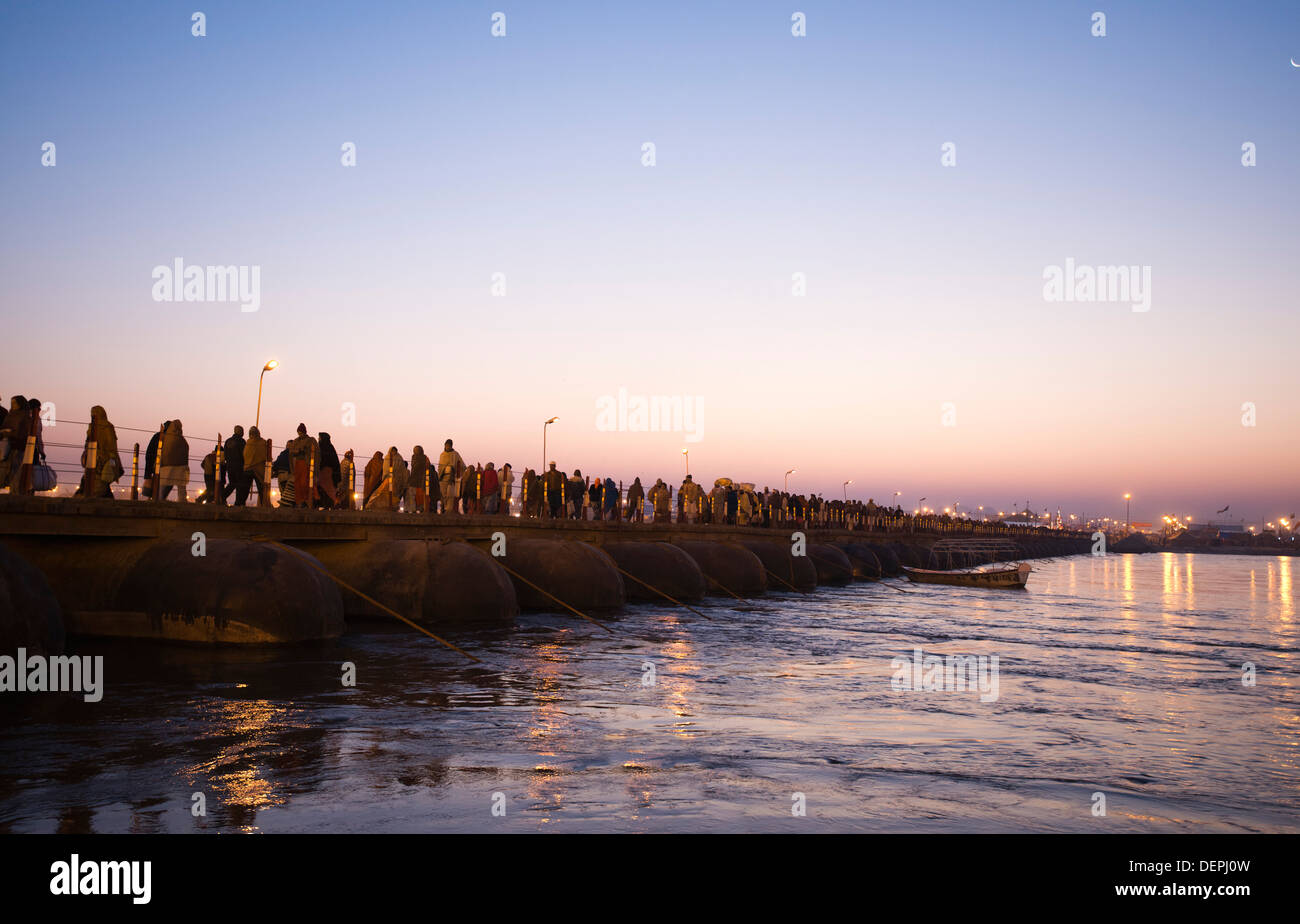 Pilgrims walking on a bridge over the Ganges River at Maha Kumbh ...