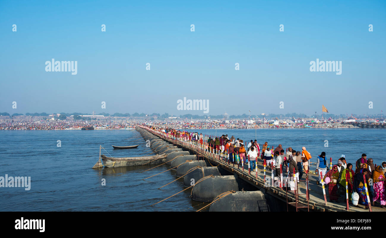 Pilgrims walking on a bridge over the Ganges River at Maha Kumbh ...