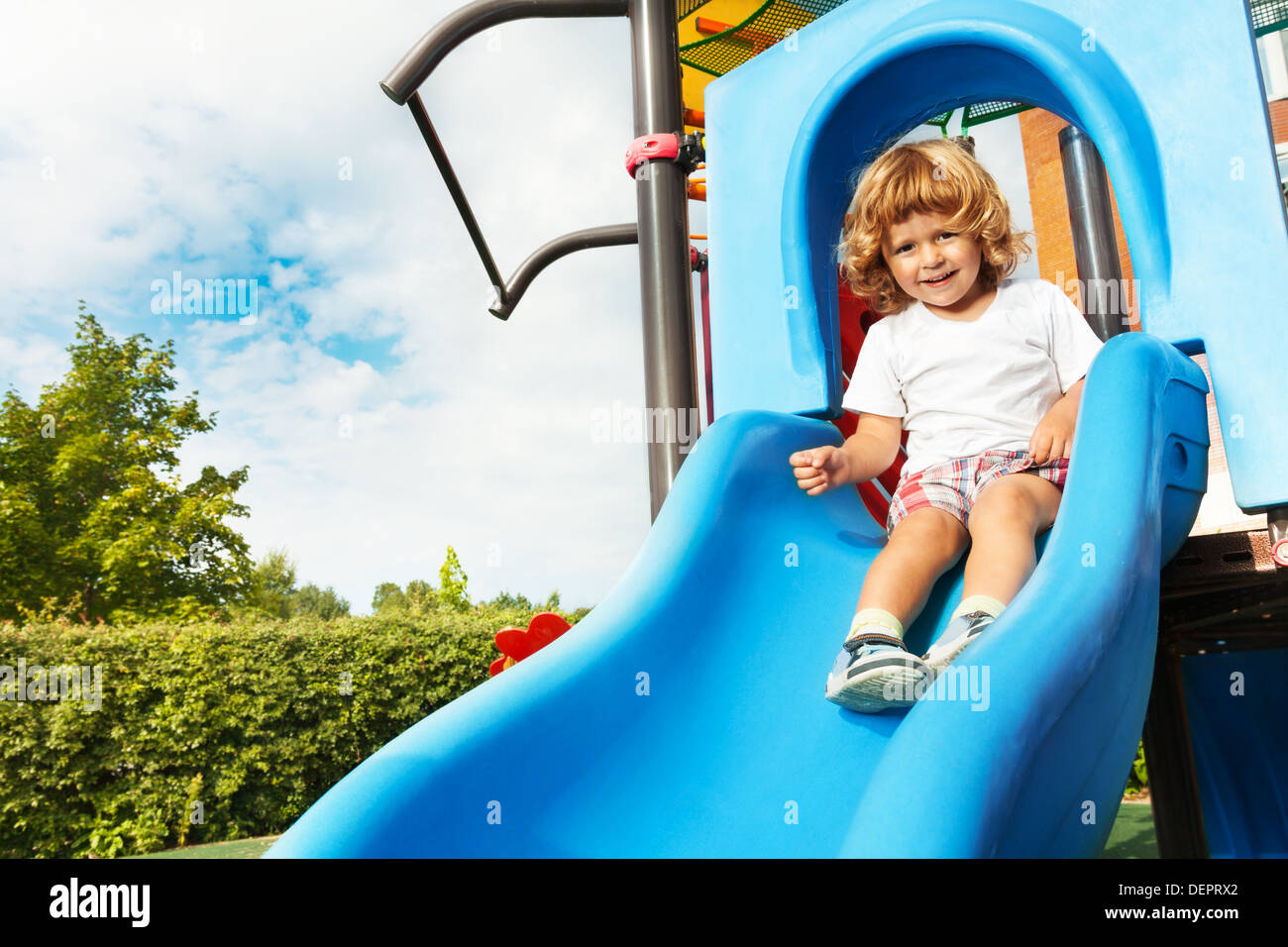 Happy kids playing on slide hi-res stock photography and images - Alamy