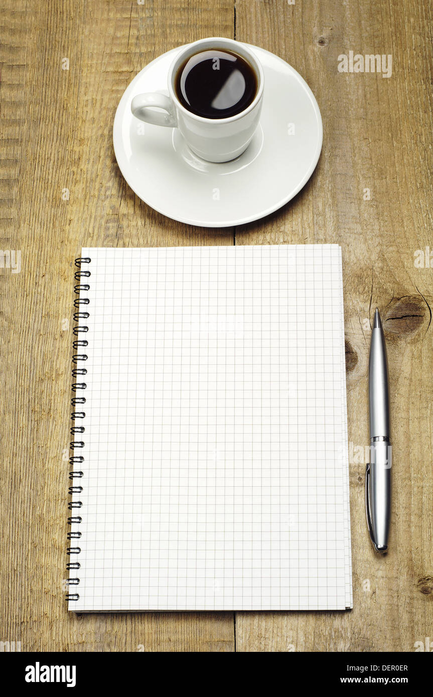 Notepad, pen and cup of coffee on a wooden table Stock Photo - Alamy