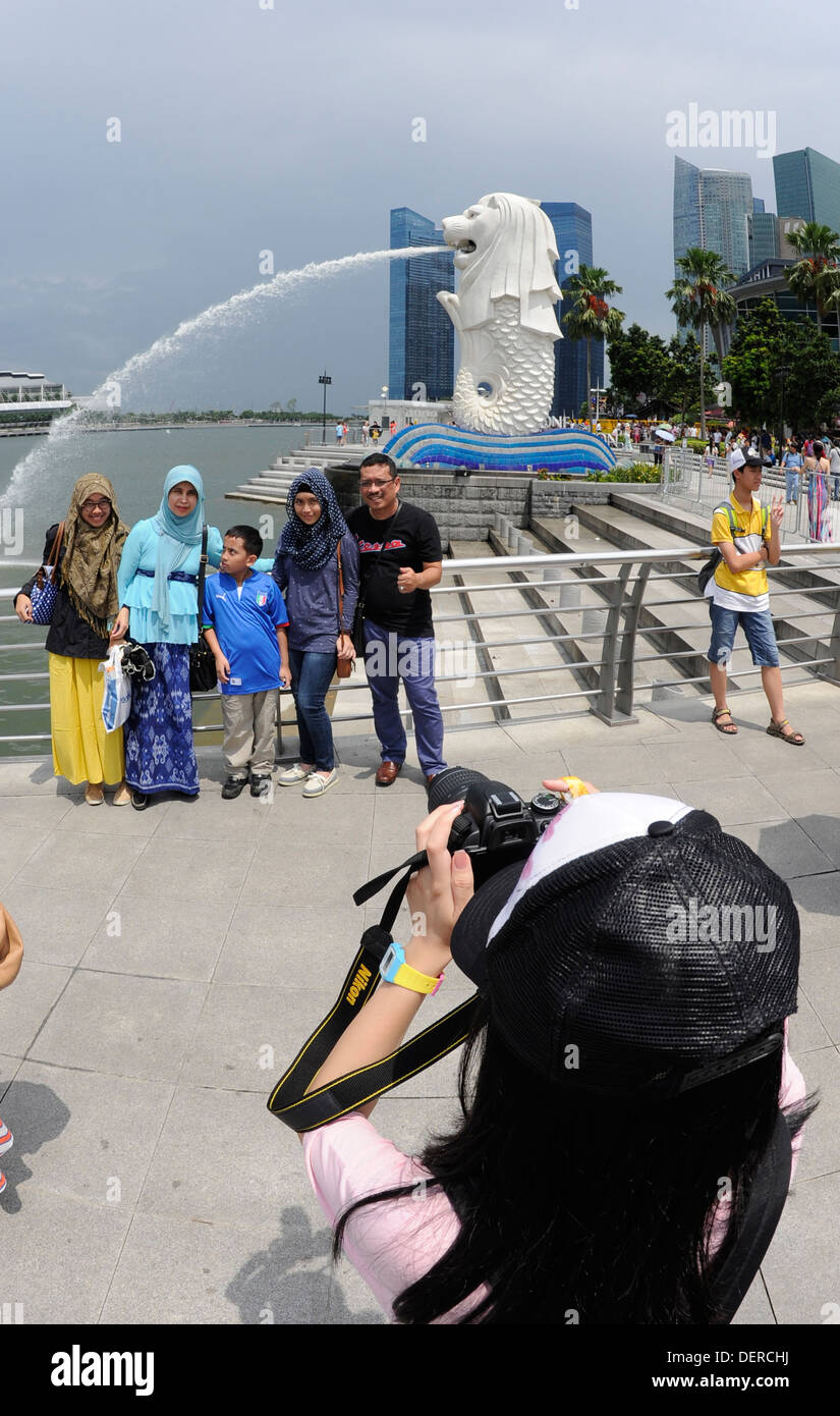 Tourist posing for photographs at the Merlion park in Singapore Stock ...