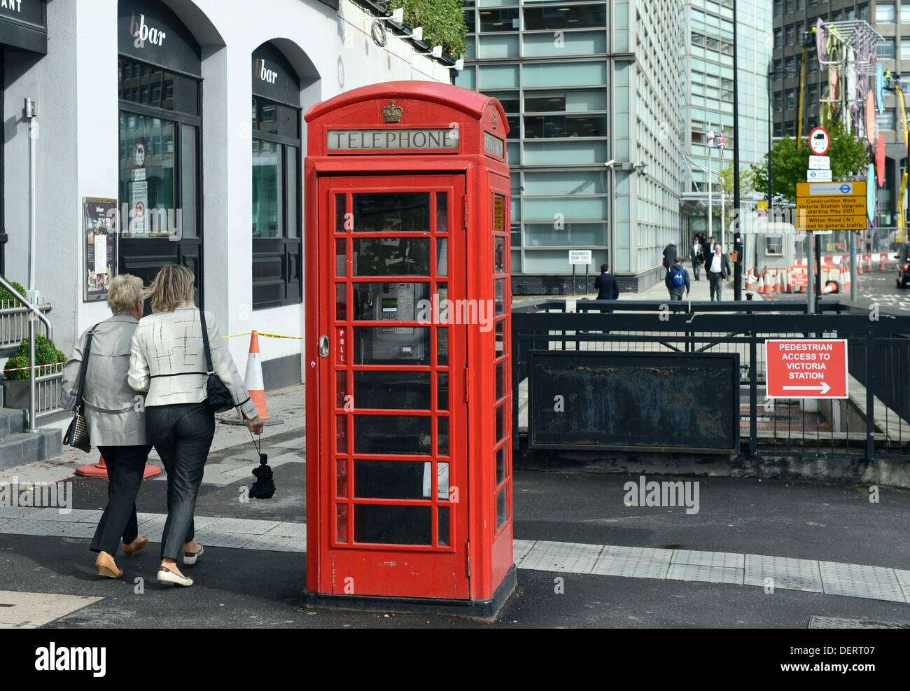 A red telephone booth is located next to Victoria Station in London ...