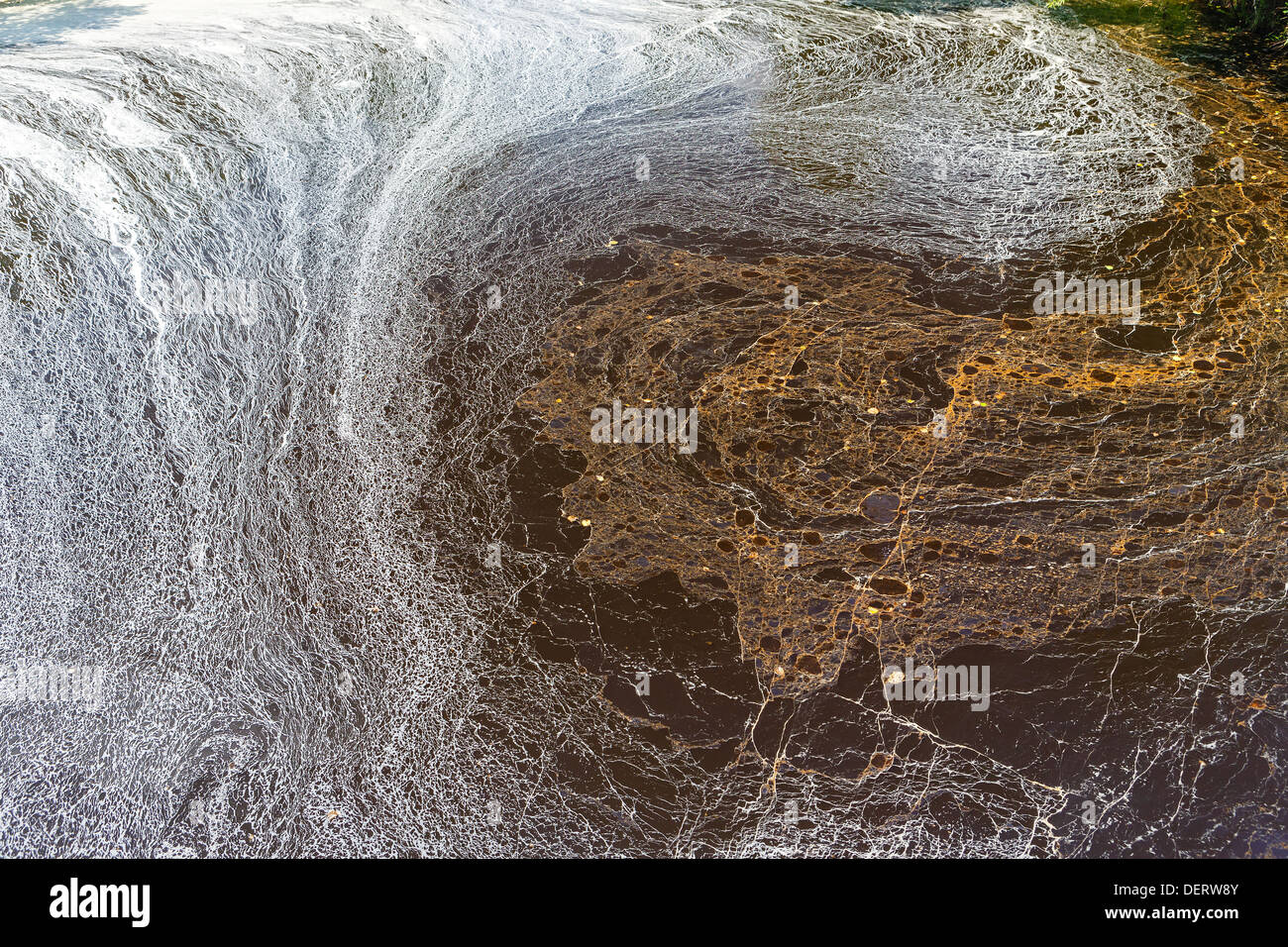 Pattern on water formed by foam and algas Stock Photo - Alamy