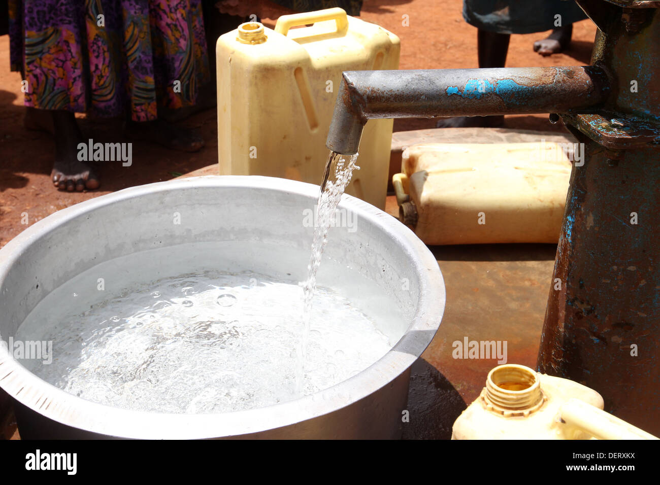 Villagers collect clean water pumped by an NGO funded well beside his ...