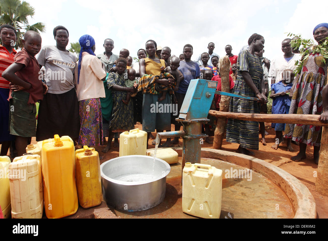 Villagers collect clean water pumped by an NGO funded well beside his ...