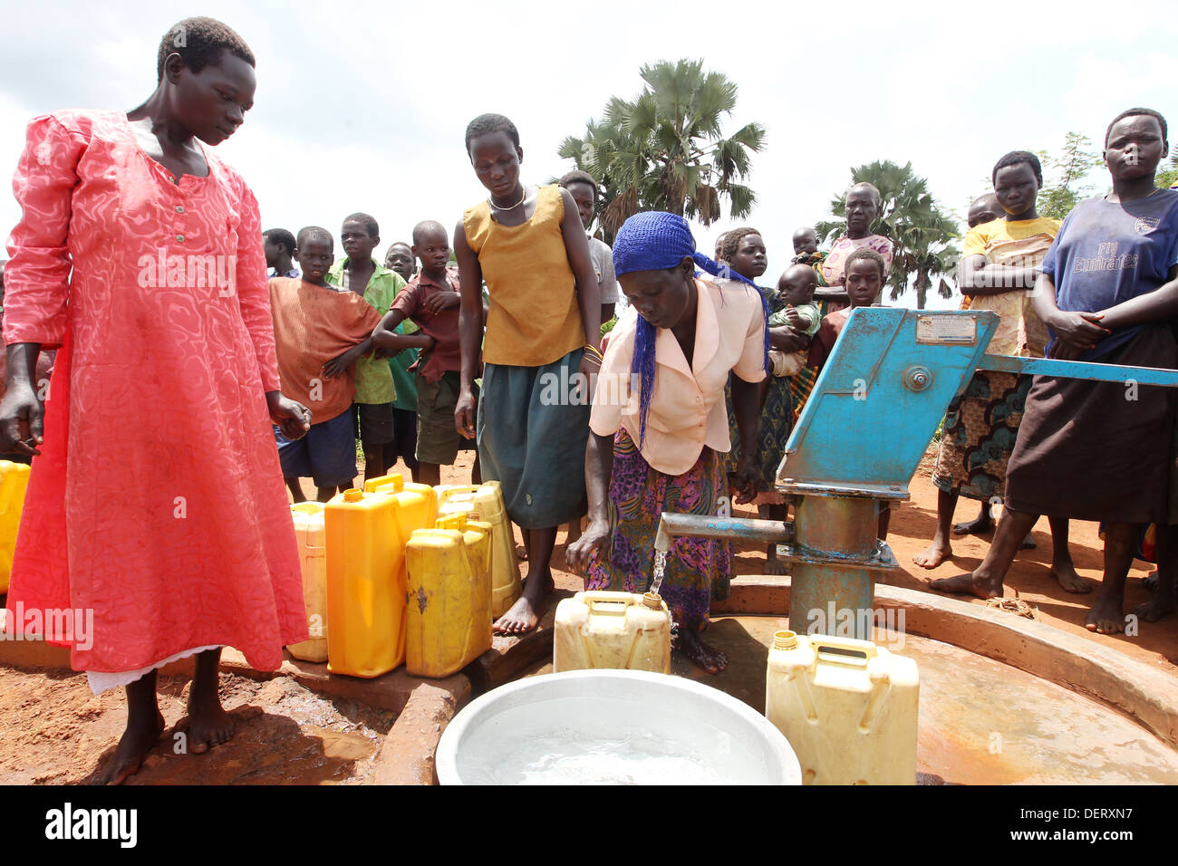 Villagers collect clean water pumped by an NGO funded well beside his ...