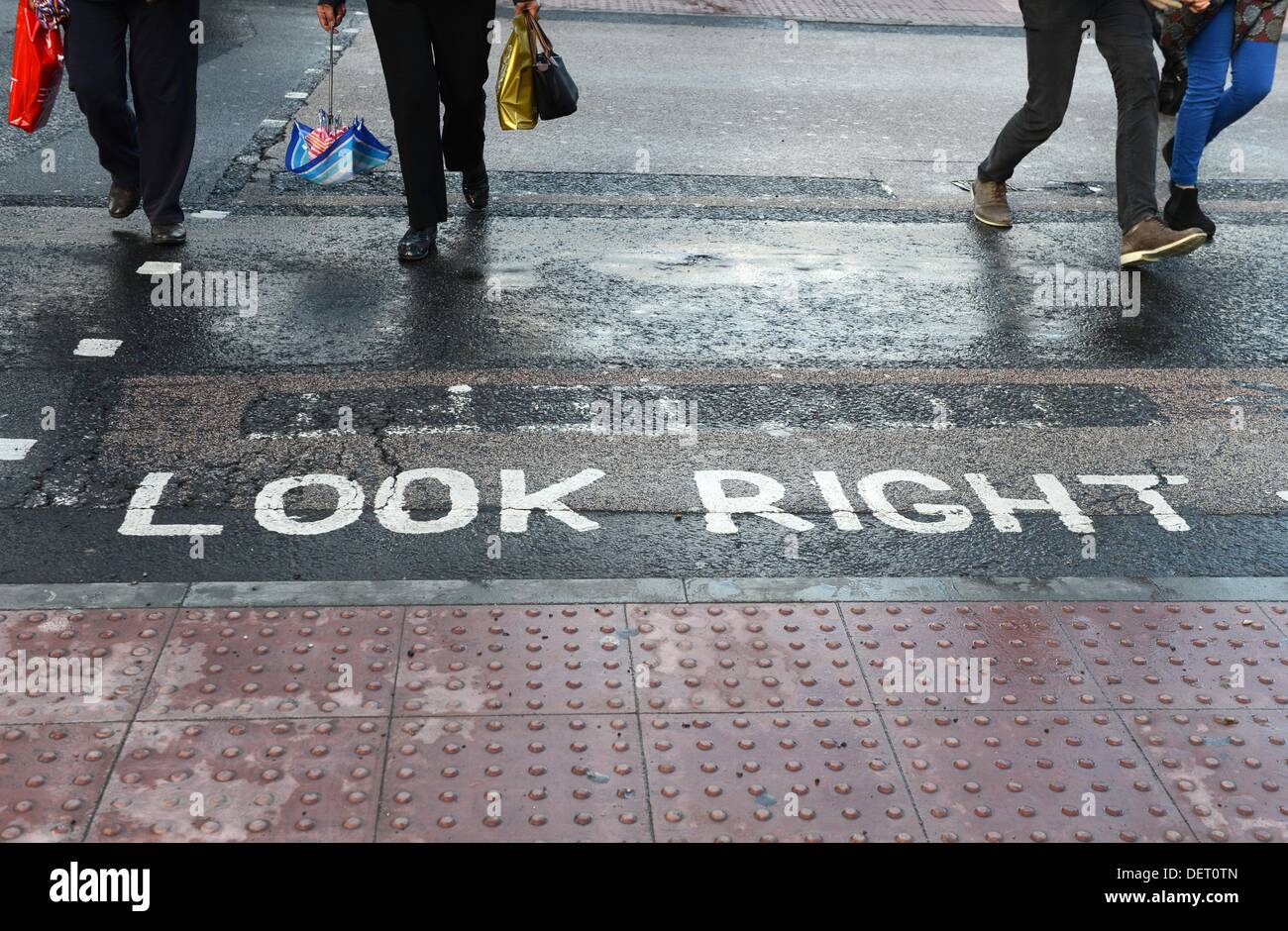 'Look Right' is written on a street next to the sidewalk to protect ...