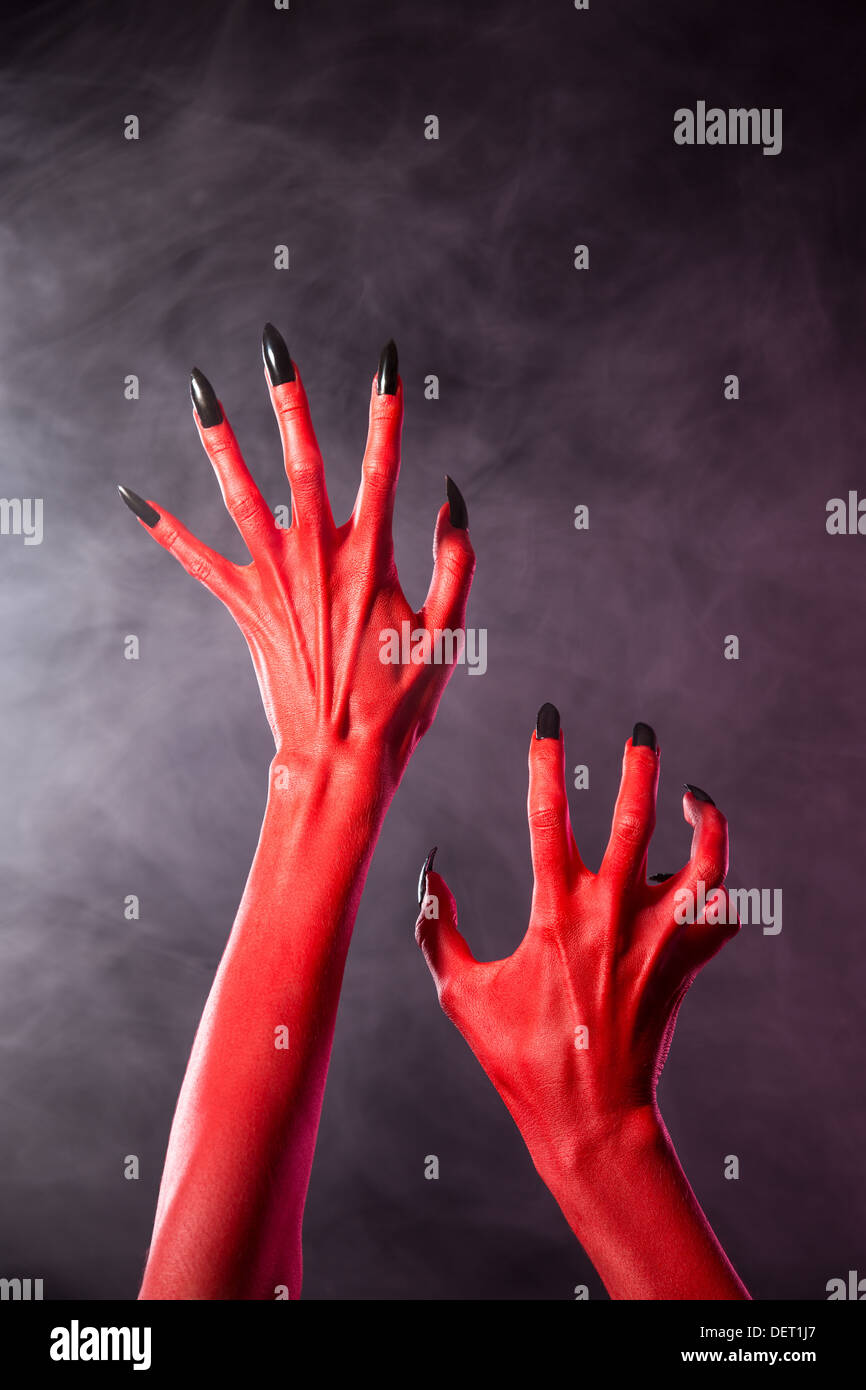 Red devil hands with black nails, Halloween theme, studio shot over ...