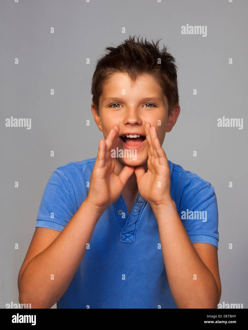 Portrait of happy young boy shouting with hands on mouse Stock Photo ...