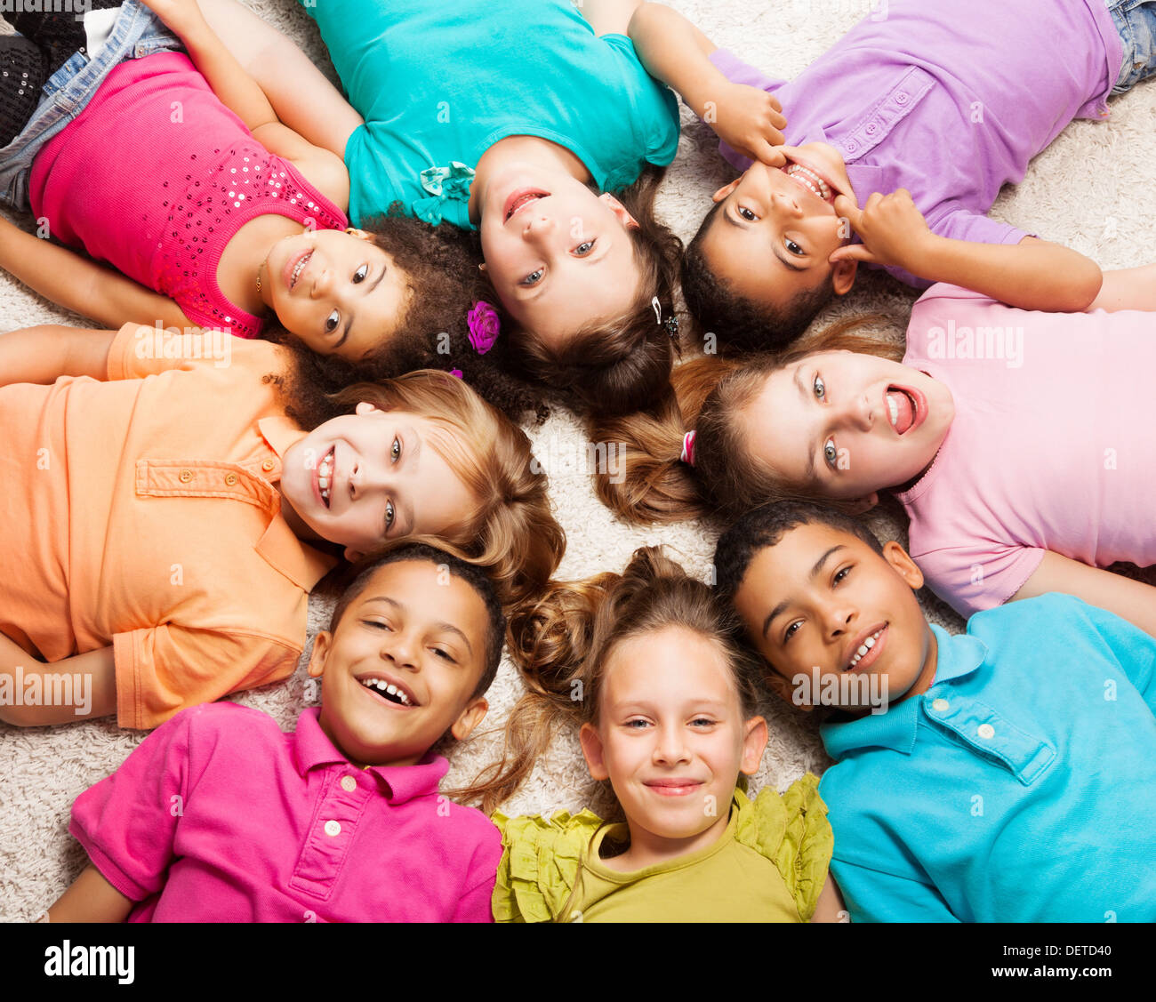 Group of eight happy diversity looking kids, boys and girls laying in ...