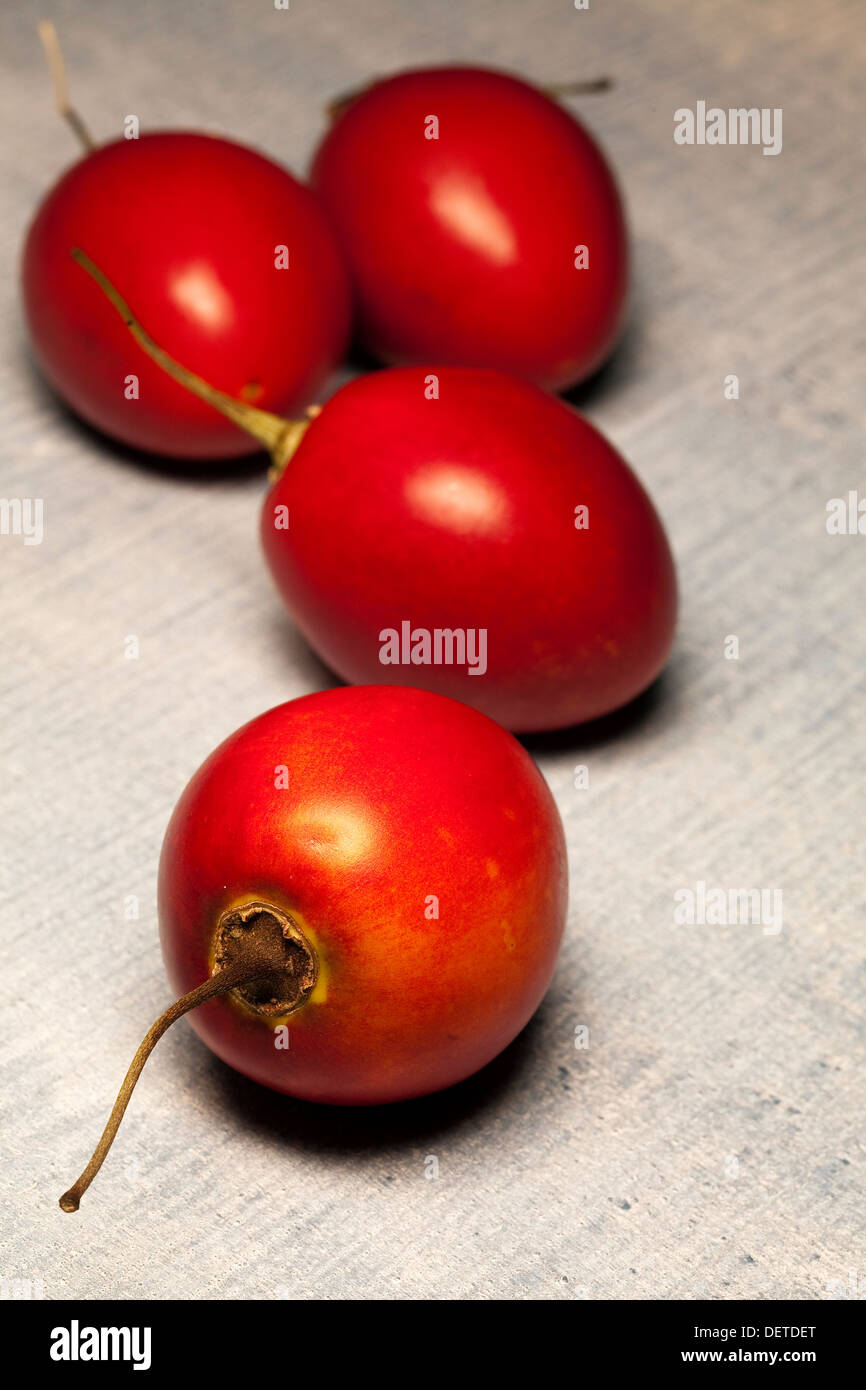 Four whole red tamarillos Stock Photo - Alamy
