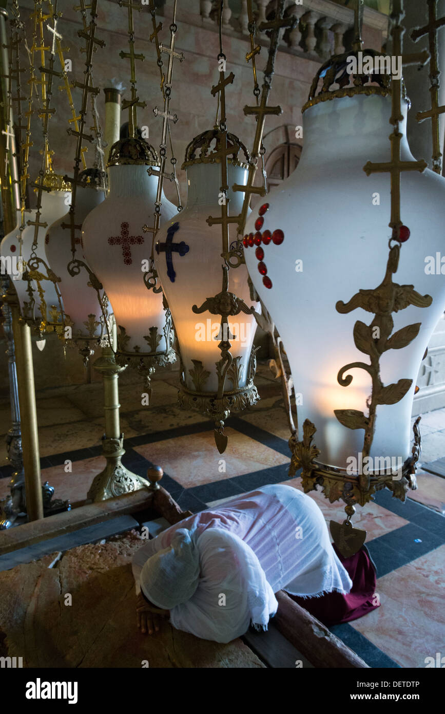 Woman in white prostrating at the Stone of Annointing. Holy sepulcher ...