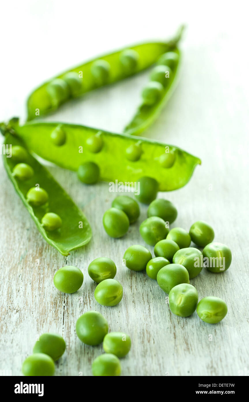 Fresh green peas - some shelled and some still in the pod - spread over ...