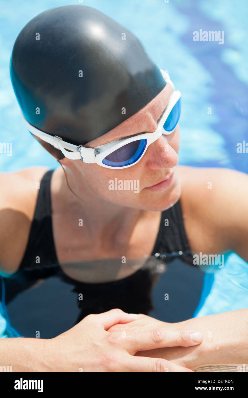 Female swimmer resting and concentrating at edge swimming pool Stock ...