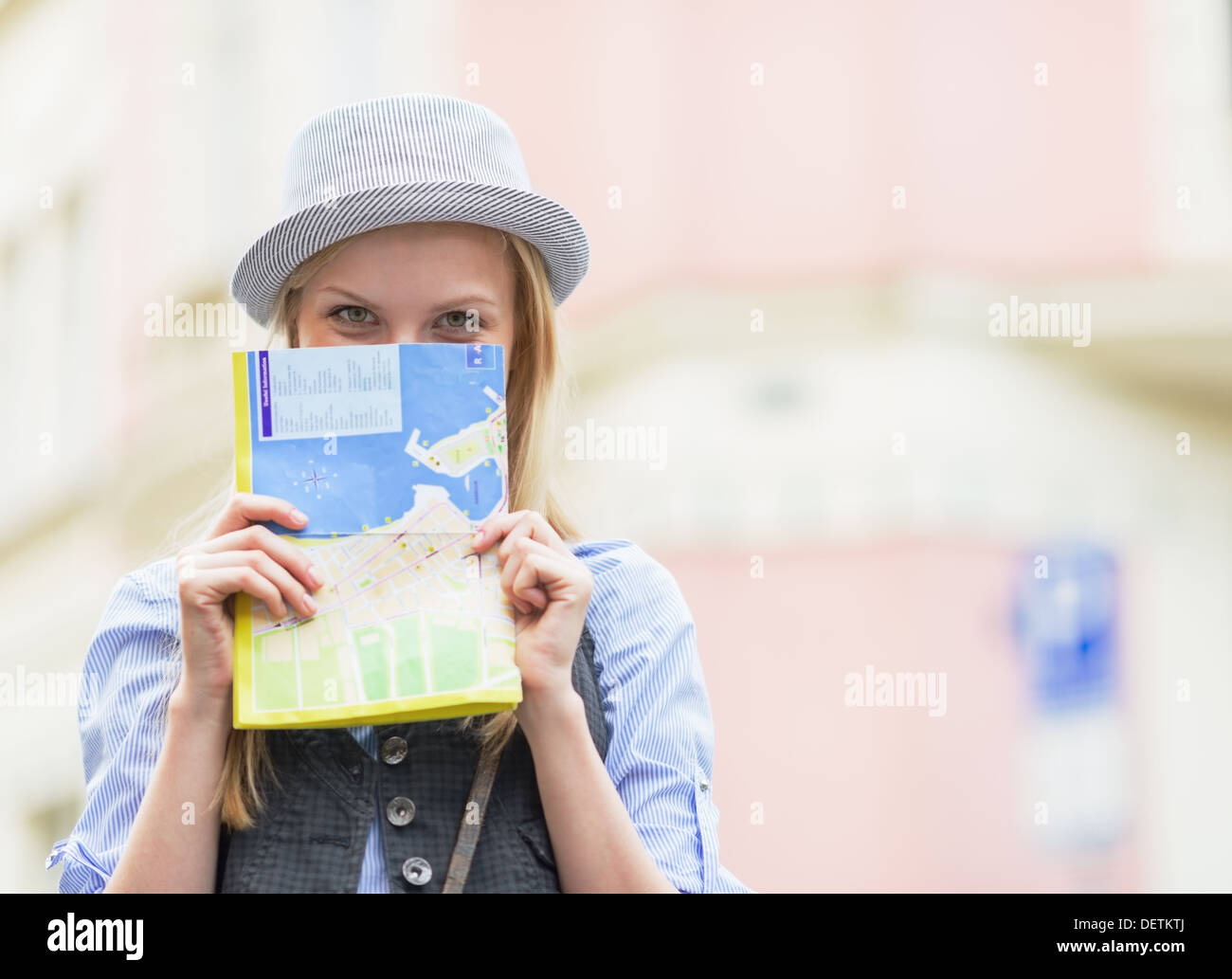 Tourist girl hiding behind map while standing on city street Stock ...