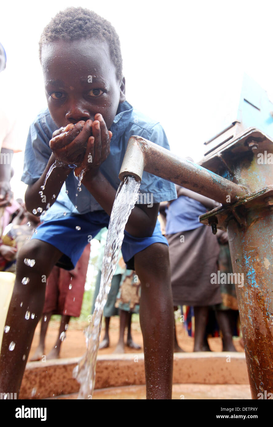A young boy collects clean water pumped by an NGO funded well beside ...