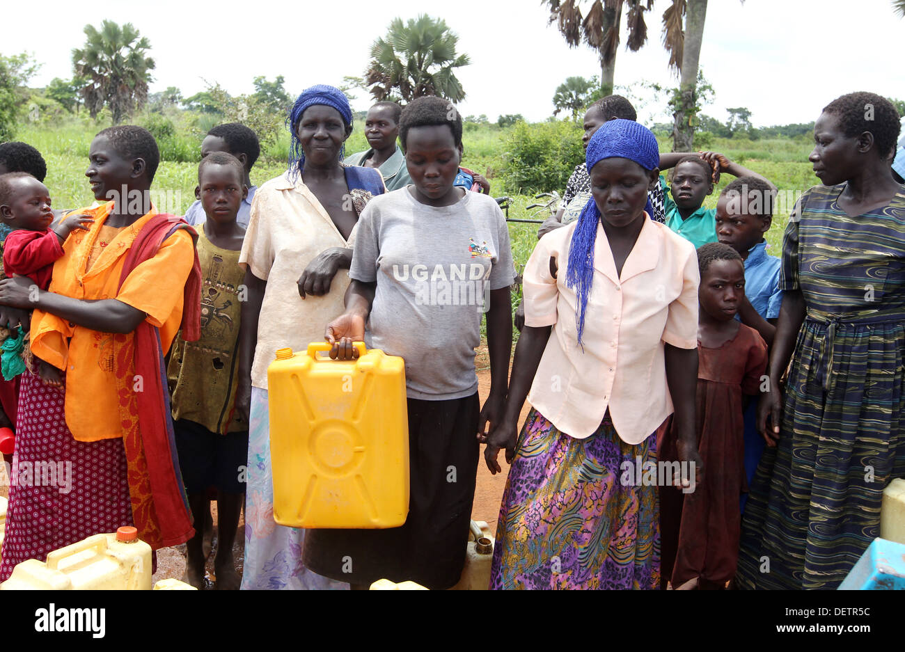 Villagers collect clean water pumped by an NGO funded well beside his ...
