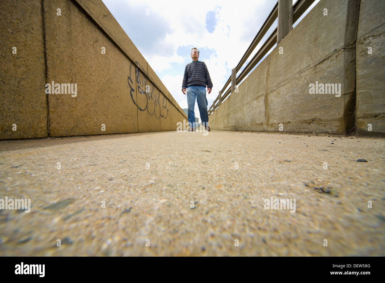 Low-angle view of a man standing on a pedestrian bridge Stock Photo - Alamy