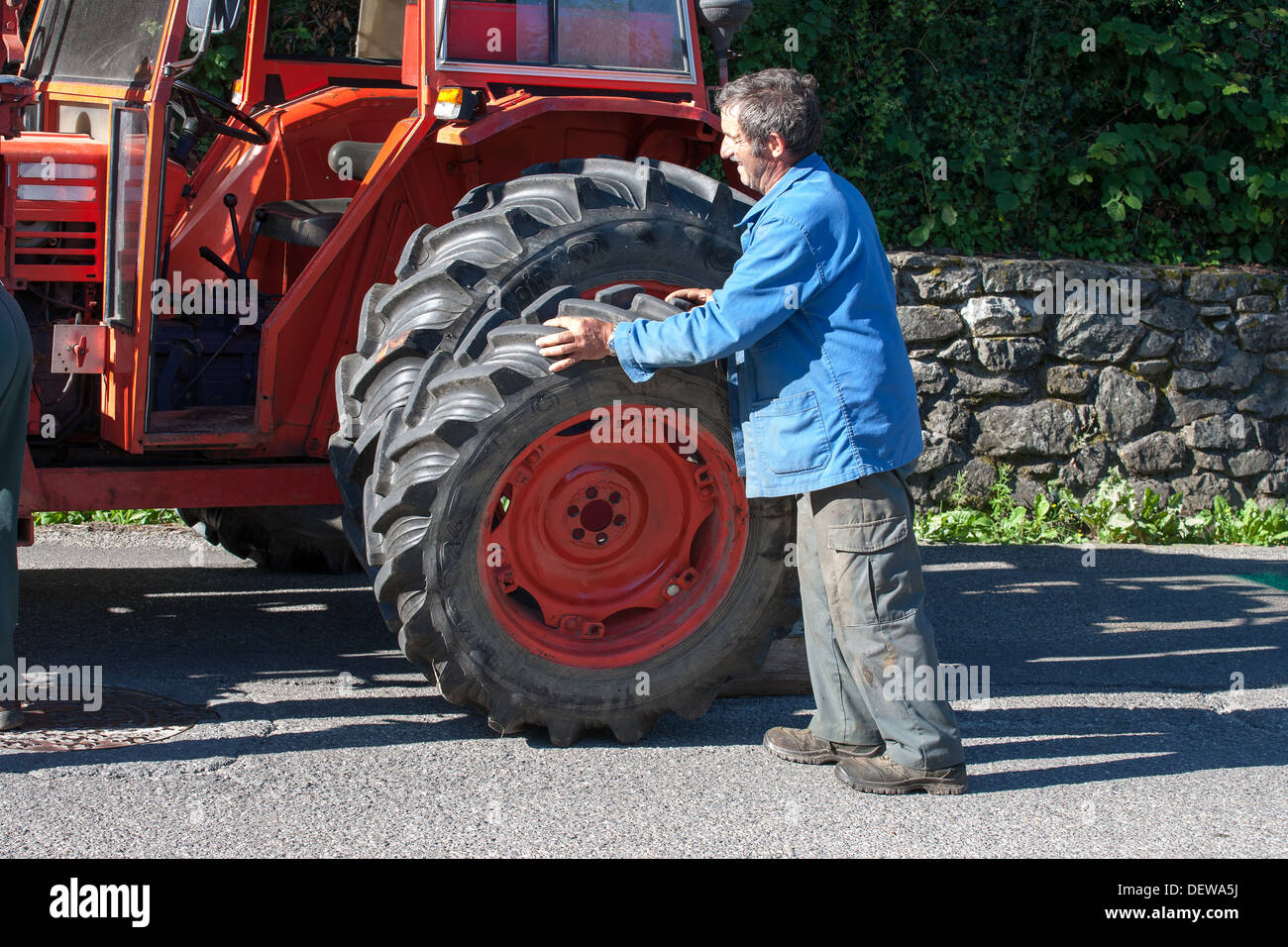 farmer farm labourer laborer repairing tractor Stock Photo - Alamy