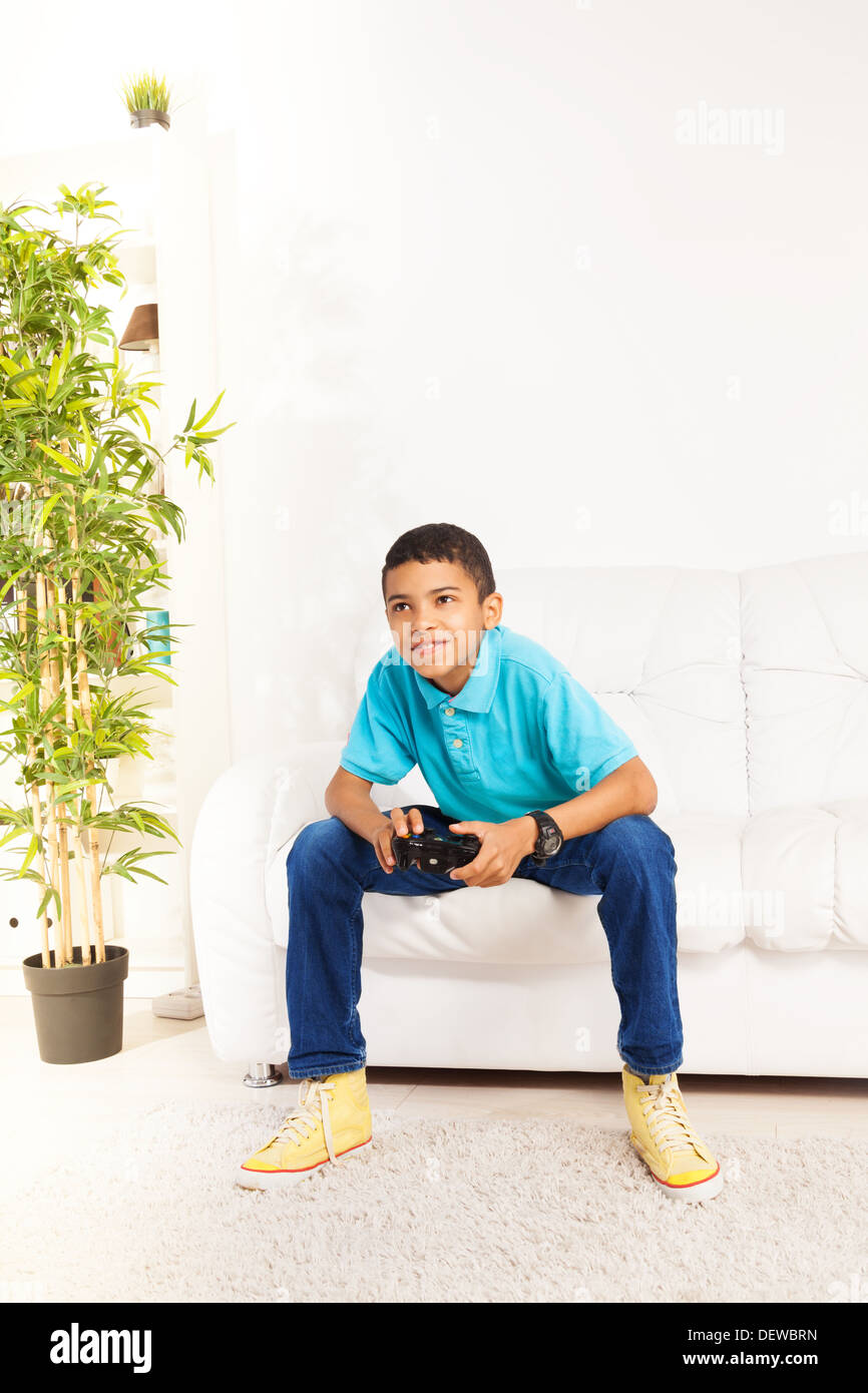 Happy black 10 years old boy playing video games holding game ...