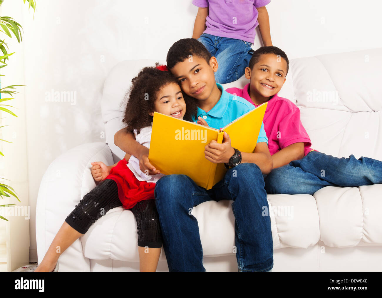 Family, group of four kids with older brother reading books to brothers ...