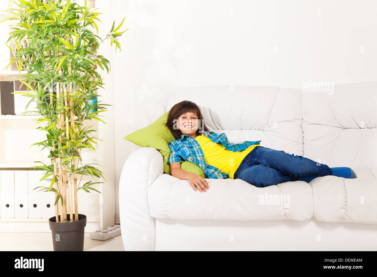 One happy smiling relaxed boy 6 years old laying on the sofa at home ...