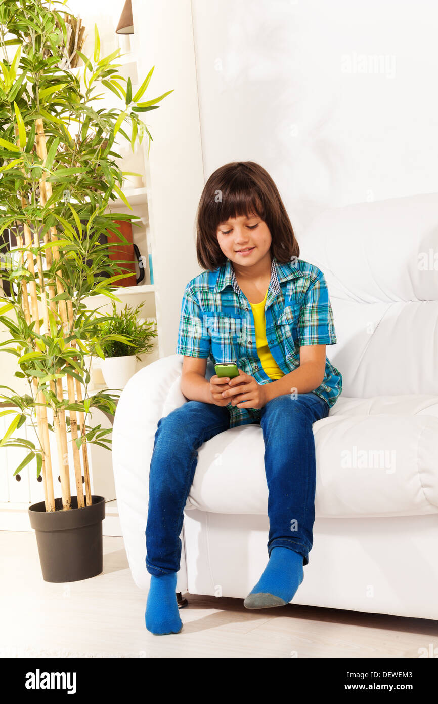 Handsome little 6 yeas old boy boy text using phone sitting on the ...