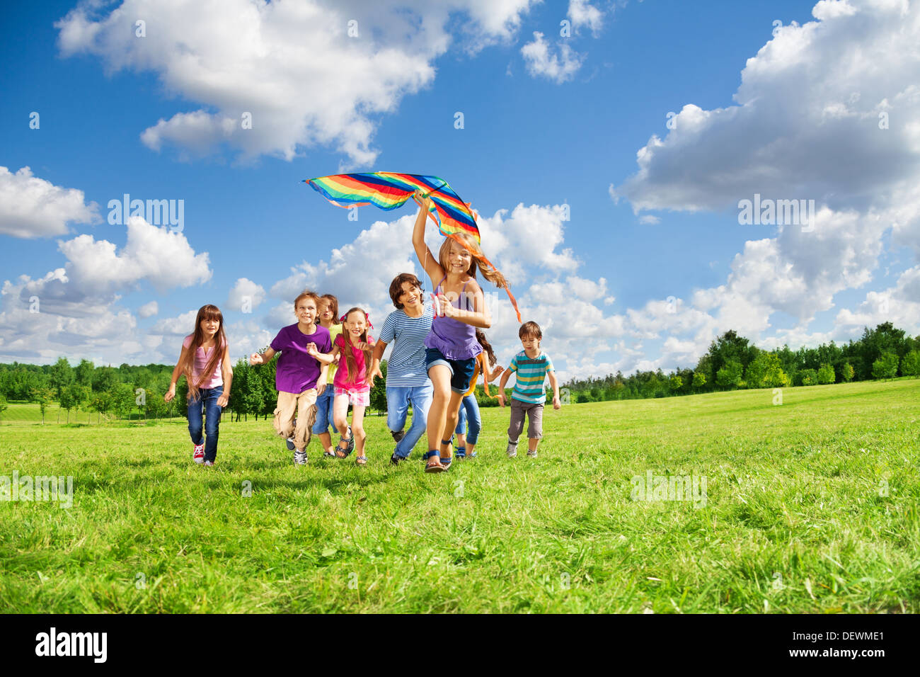 Cute happy active kids boys and girls run with kite in the park and ...