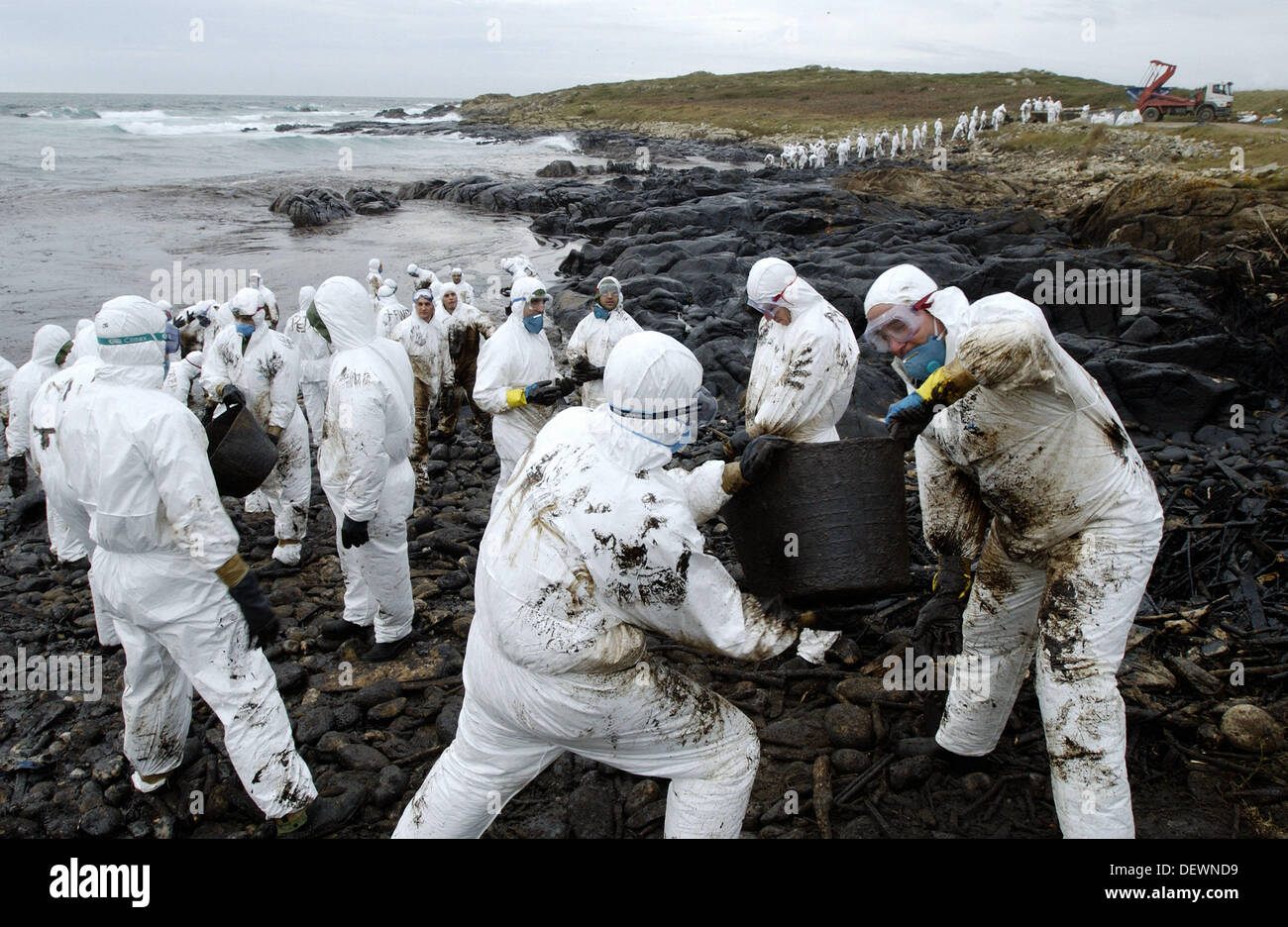Soldiers dressed with protective clothing cleaning up the oil spill ...