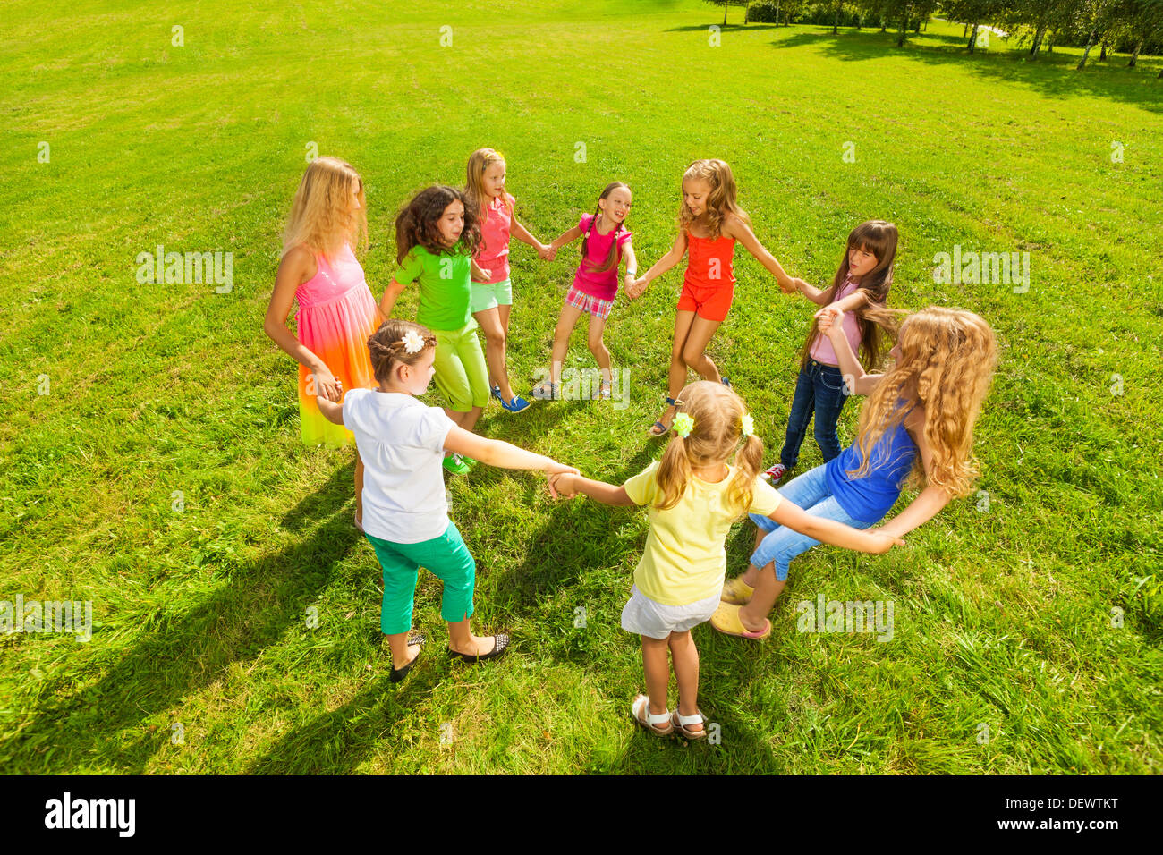 many happy girls play roundelay and dance and stand in circle in the ...