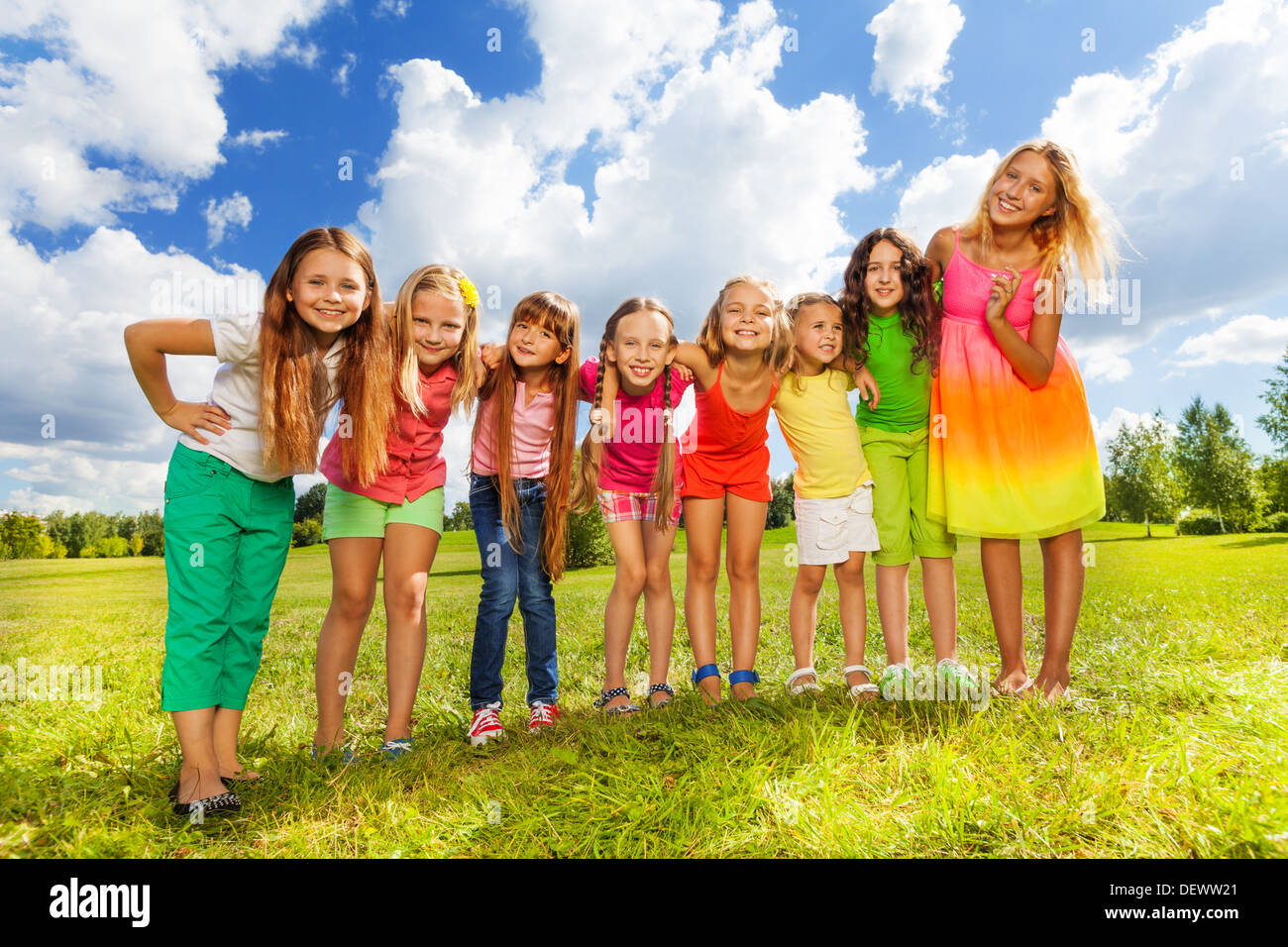 Large group of happy girls standing in a row in the park on the green ...