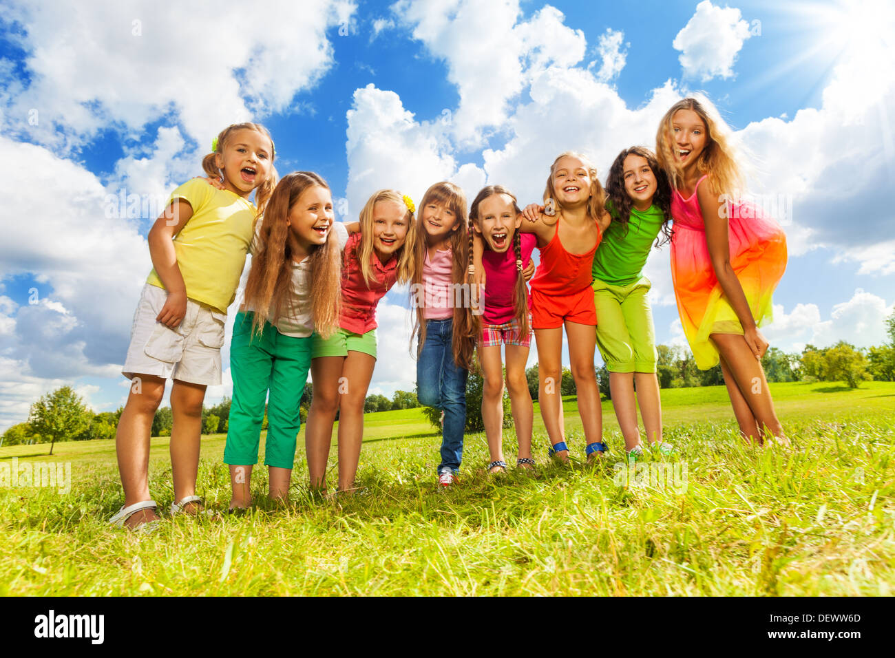 Large group of happy cute girls friends standing in a row in the park ...